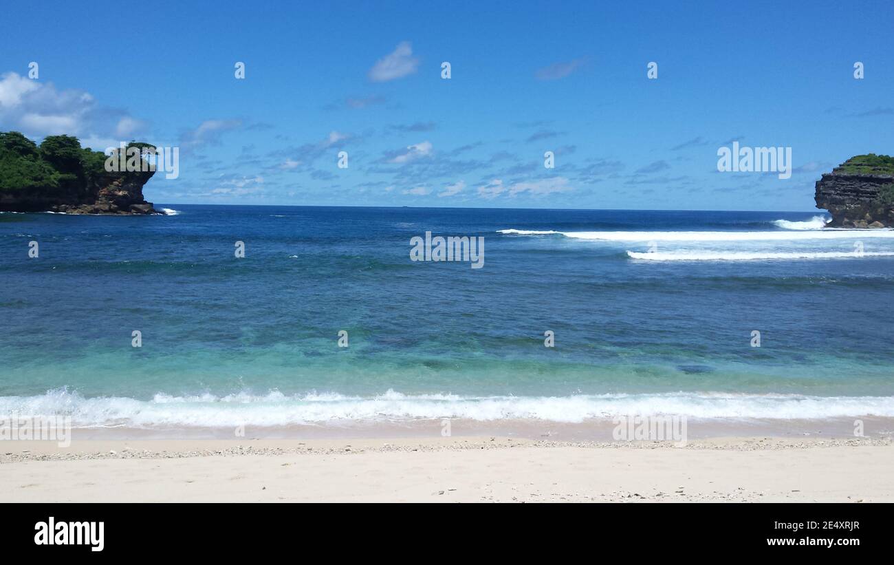 beach view with sand beach, blue ocean, blue sky and rocks from Stock ...