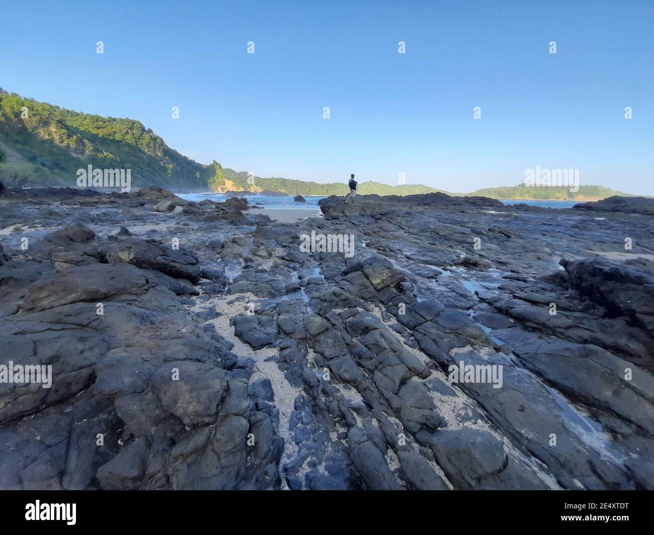 A wide rock plateau mixed with sand and water from sea waves Stock ...