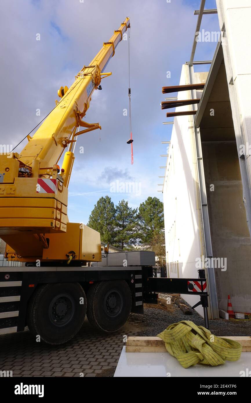 Vertical low angle shot of a tall mobile crane on a construction site ...