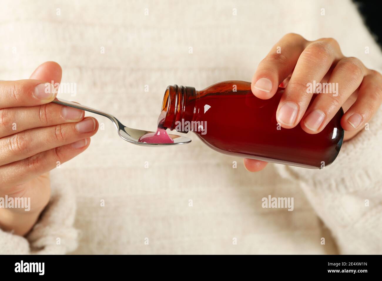Woman pouring syrup in spoon, close up Stock Photo - Alamy