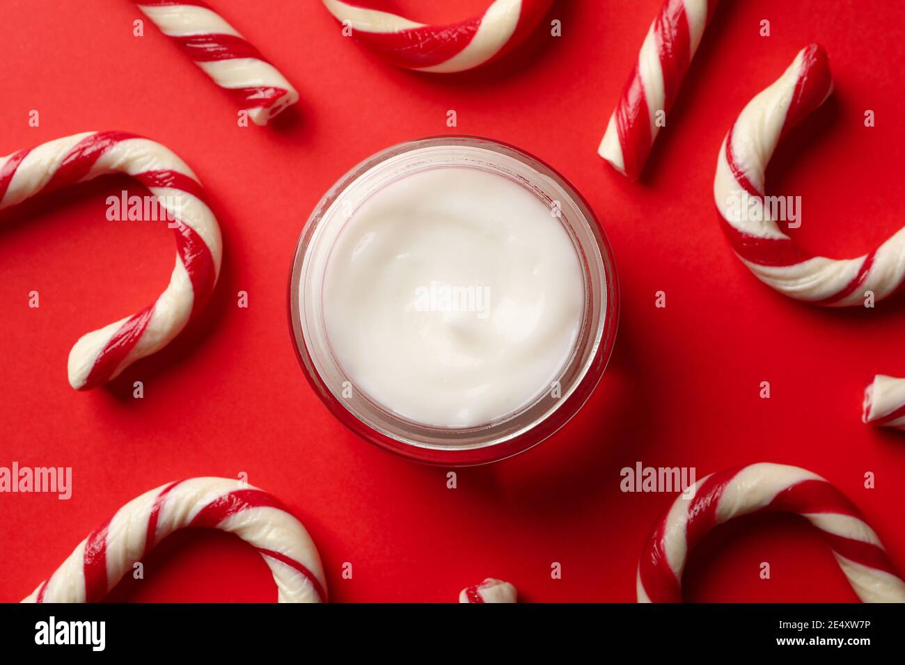 Jar of cosmetic cream and candy canes on red background Stock Photo - Alamy