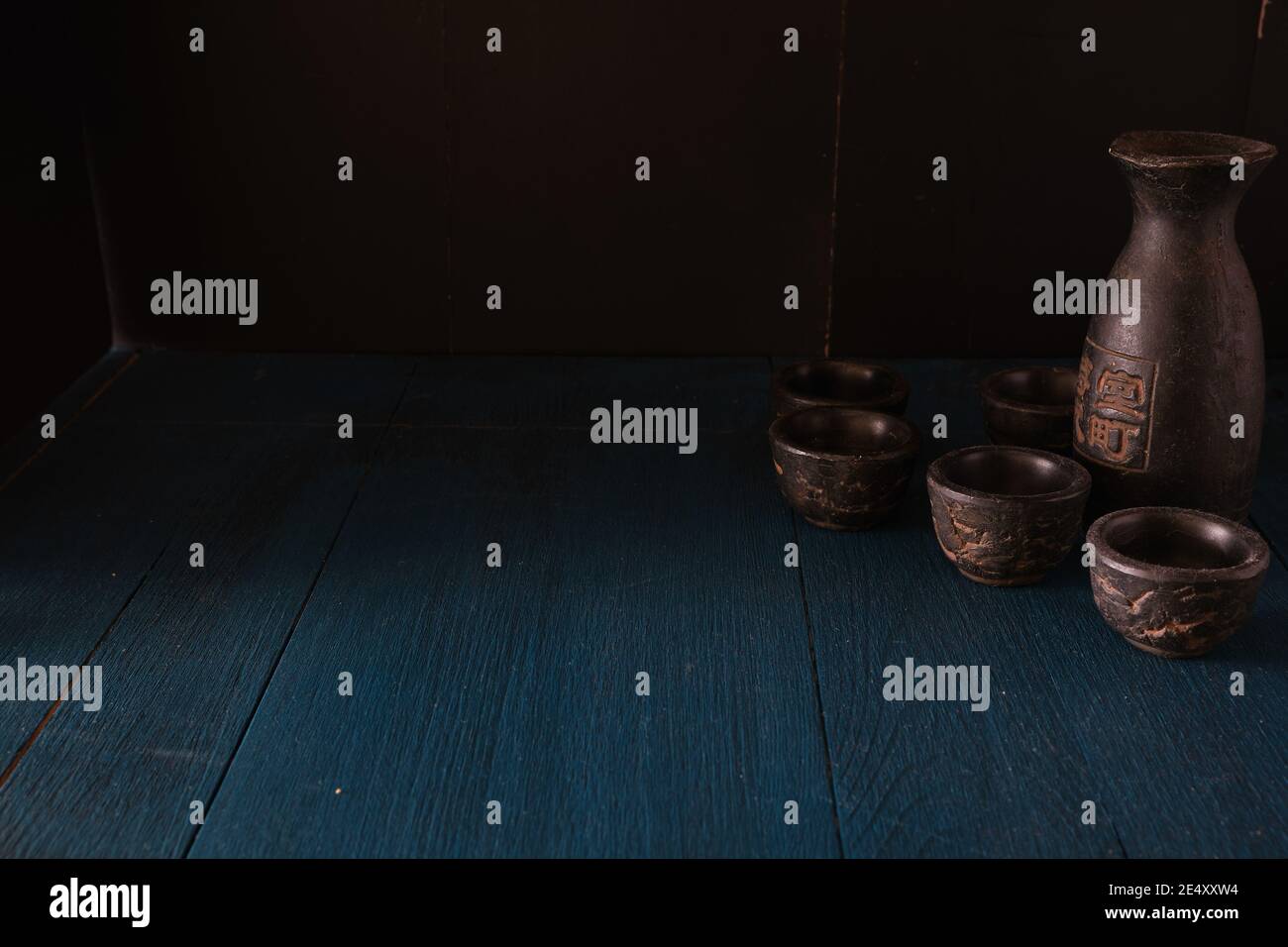 sake set in dark background over blue wood table Stock Photo - Alamy