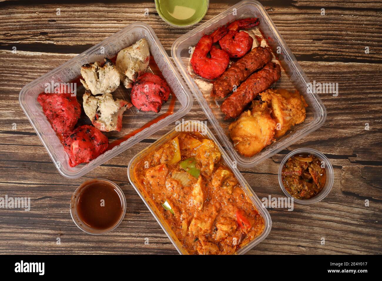 Top view of traditional Indian food in a plastic box on a wooden table ...