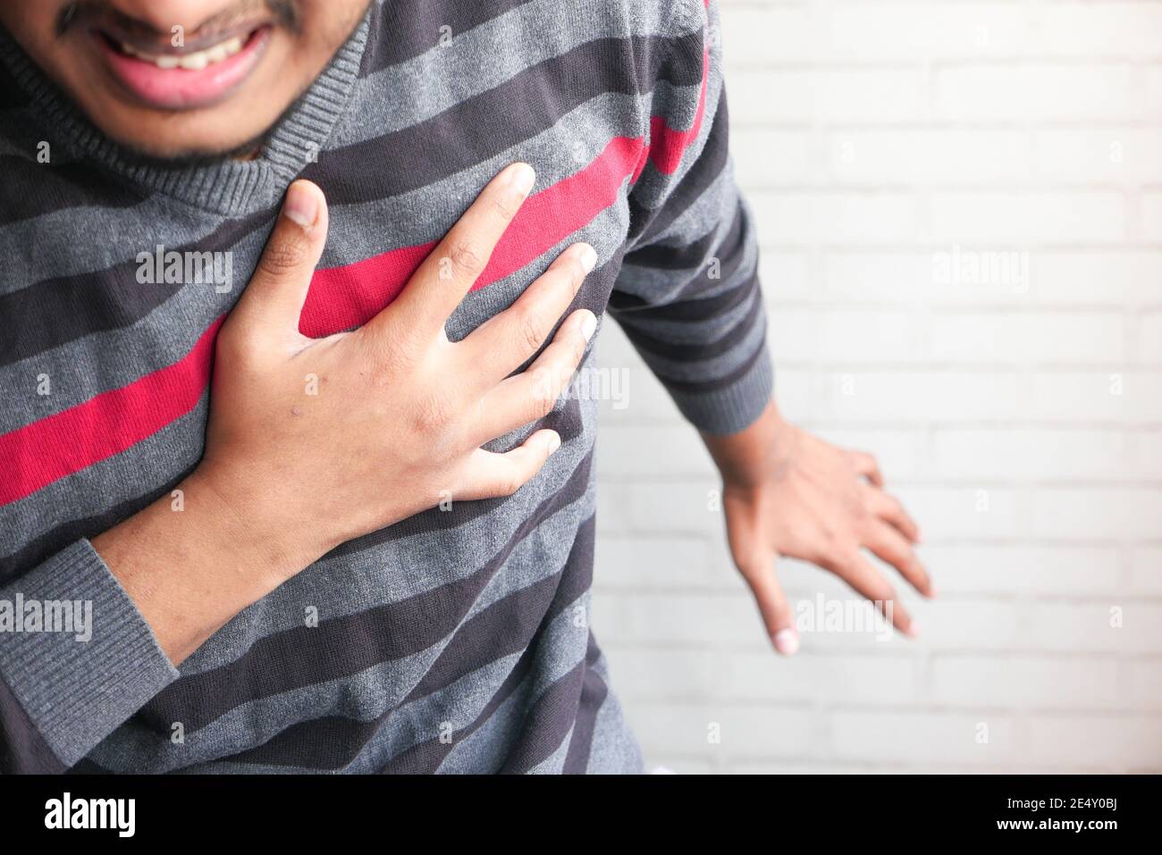 the concept of heart attack , man having pain in heart and holding ...