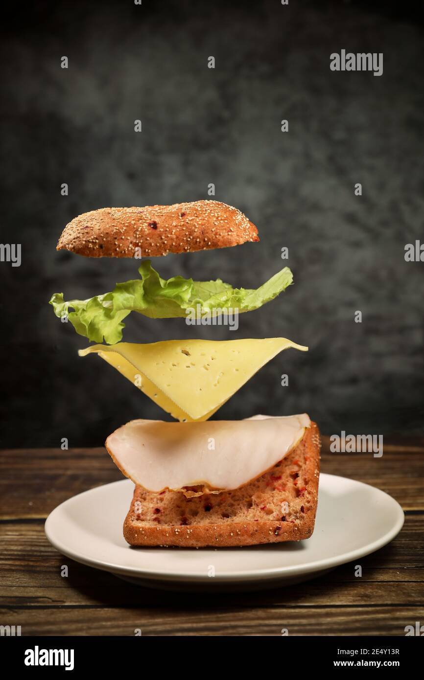Homemade flying sandwich ingredients on a plate and wooden table ...