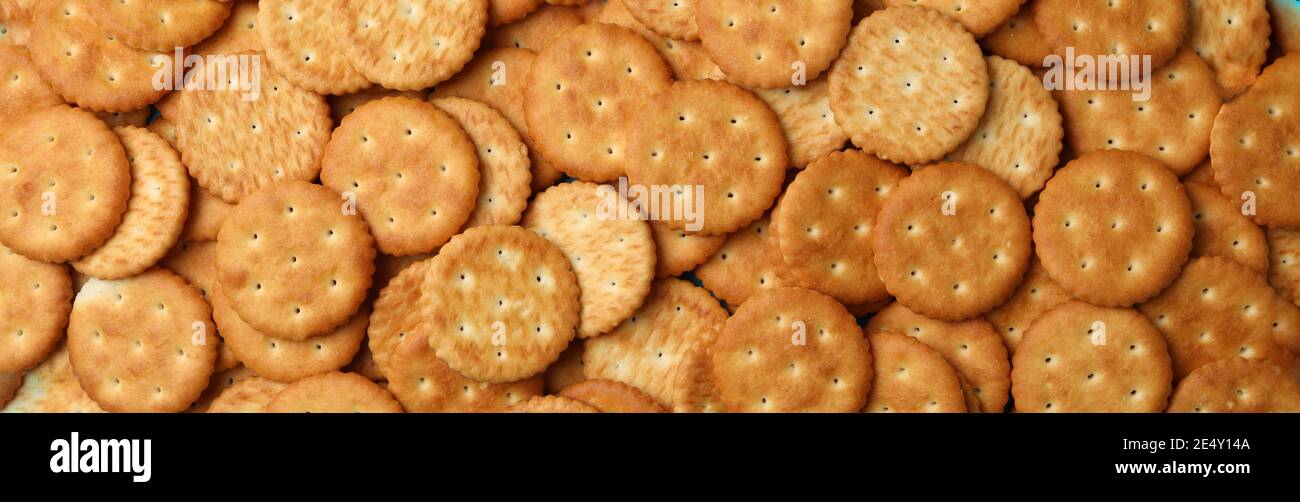 Tasty cracker biscuits on whole background, top view Stock Photo - Alamy