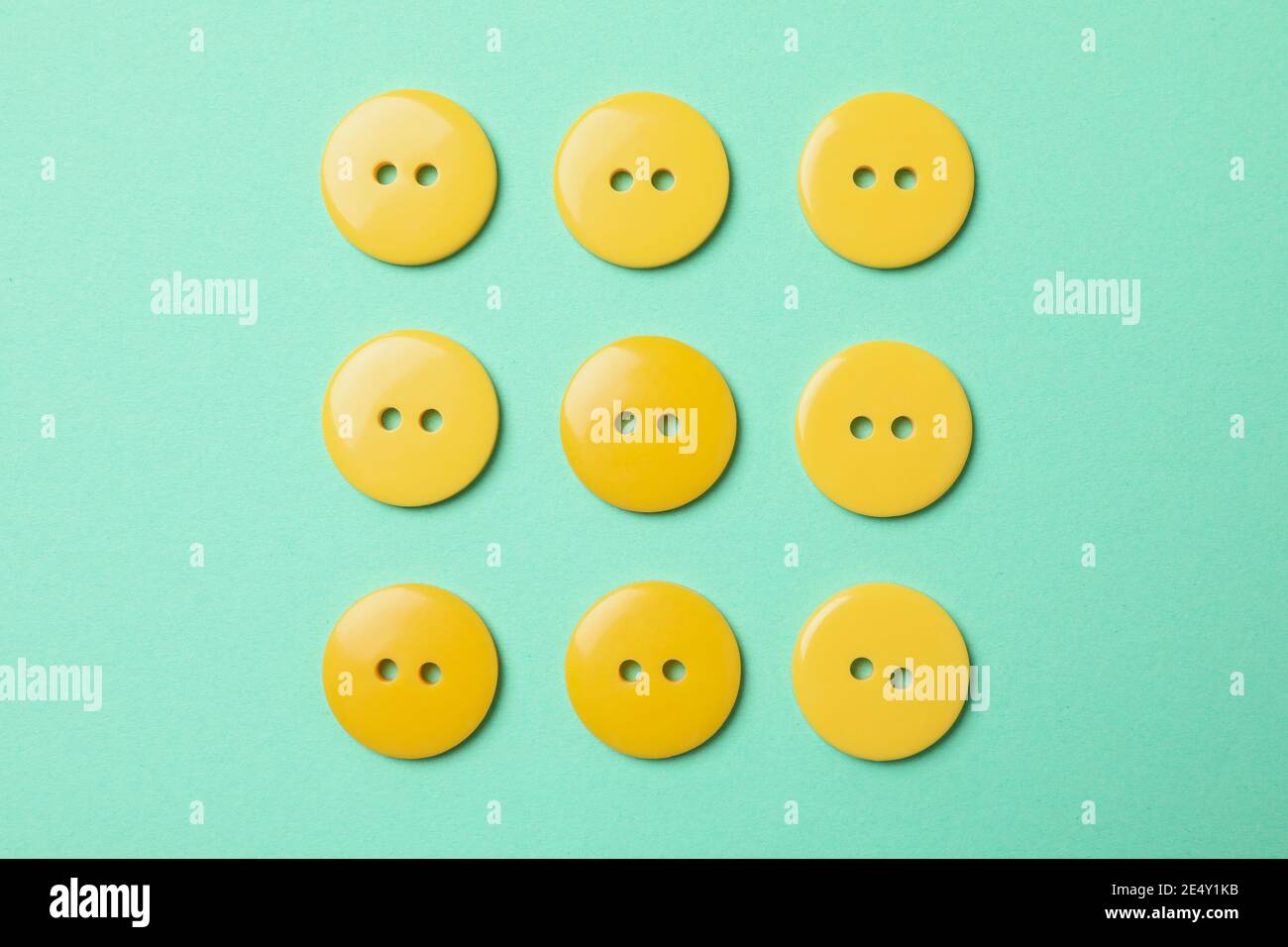 Flat lay with yellow buttons on mint background Stock Photo - Alamy
