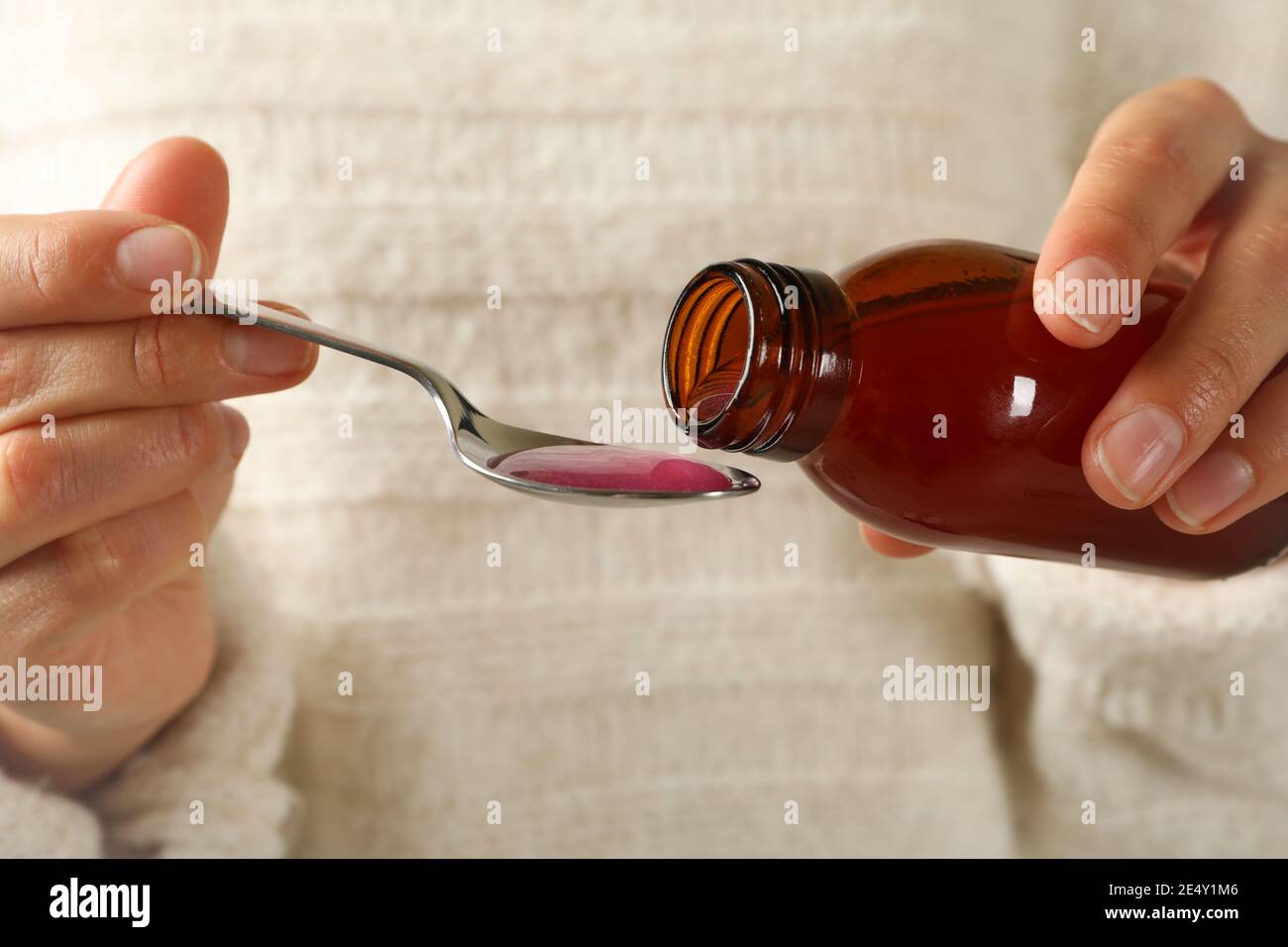 Woman pouring syrup in spoon, close up Stock Photo - Alamy