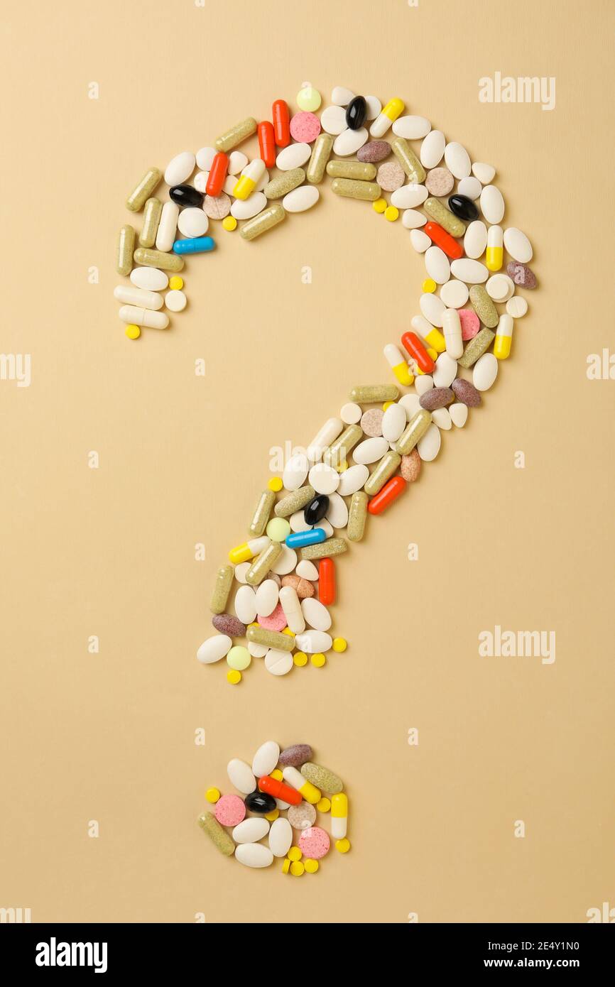 Question mark made of pills on beige background Stock Photo - Alamy