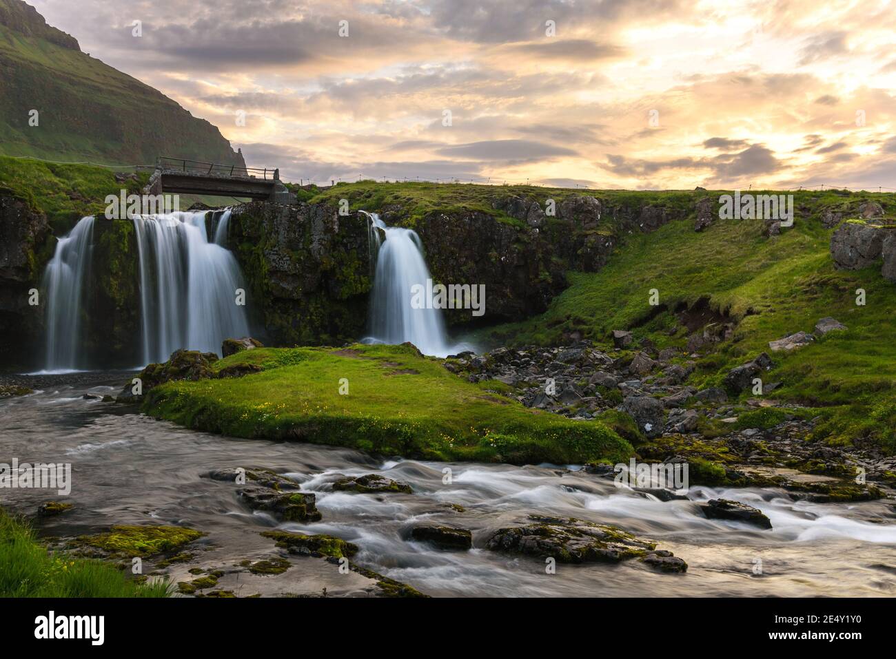 Small bridge over a beautiful waterfall at sunet Stock Photo - Alamy