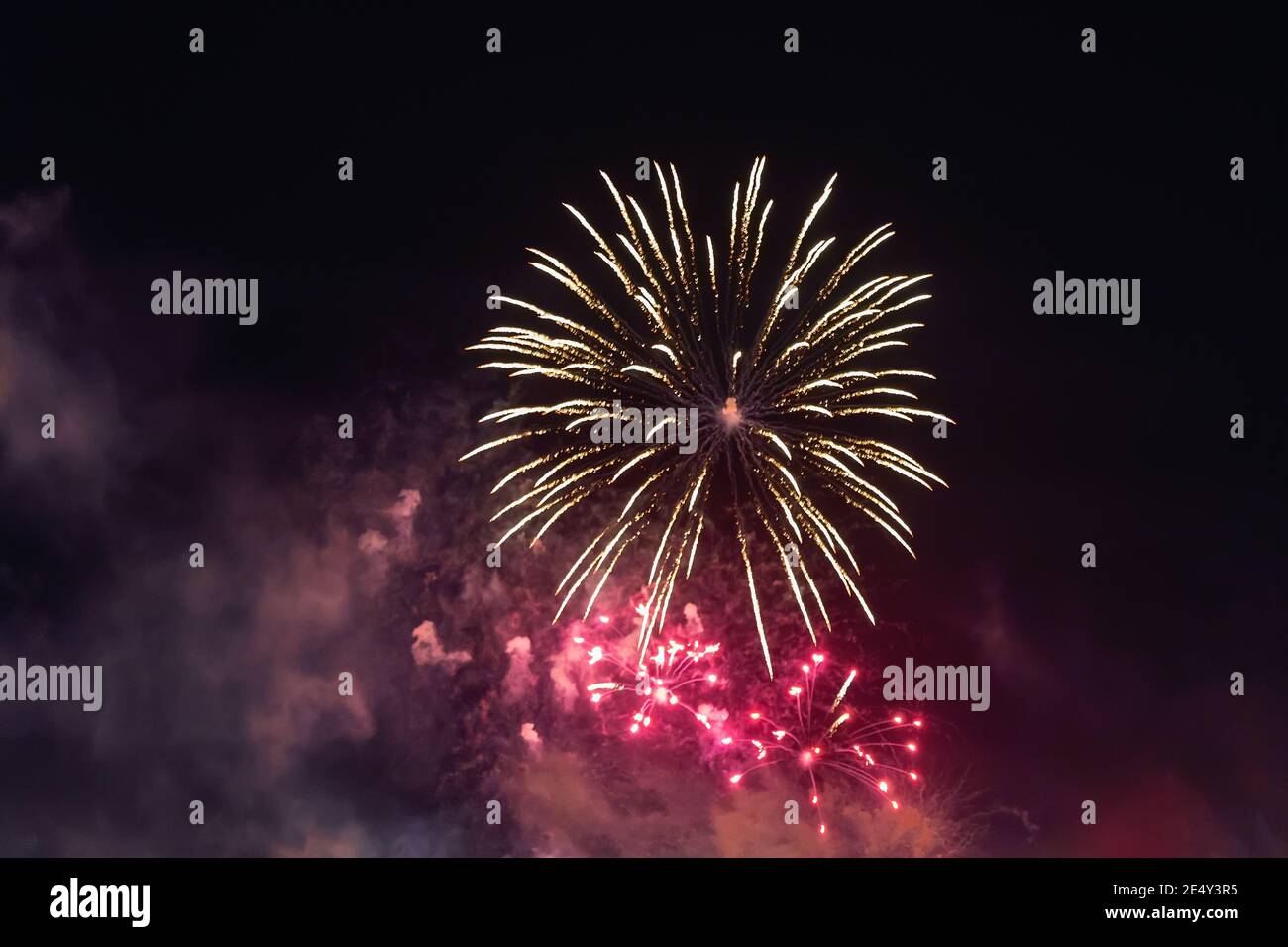 Bright red fireworks lights in the night sky. Small city celebrates new ...