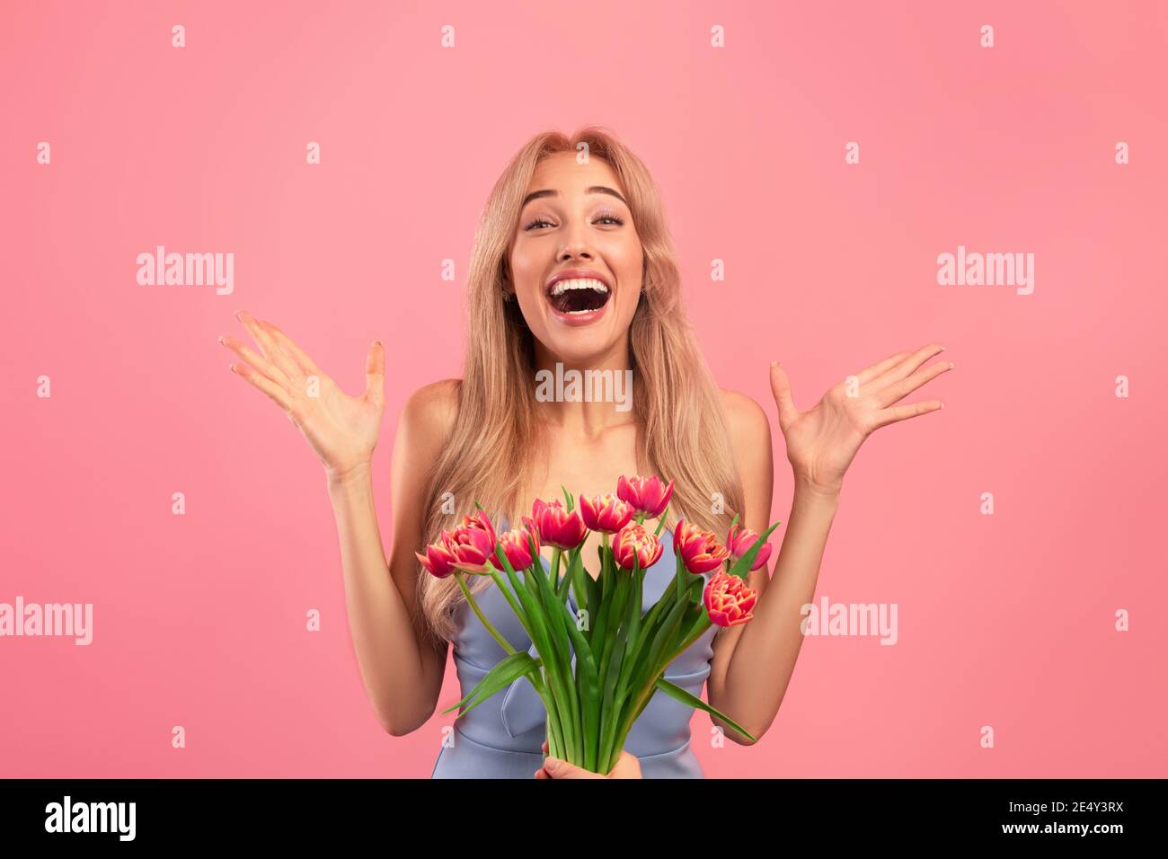 Beautiful millennial blonde feeling excited to receive lovely flower ...