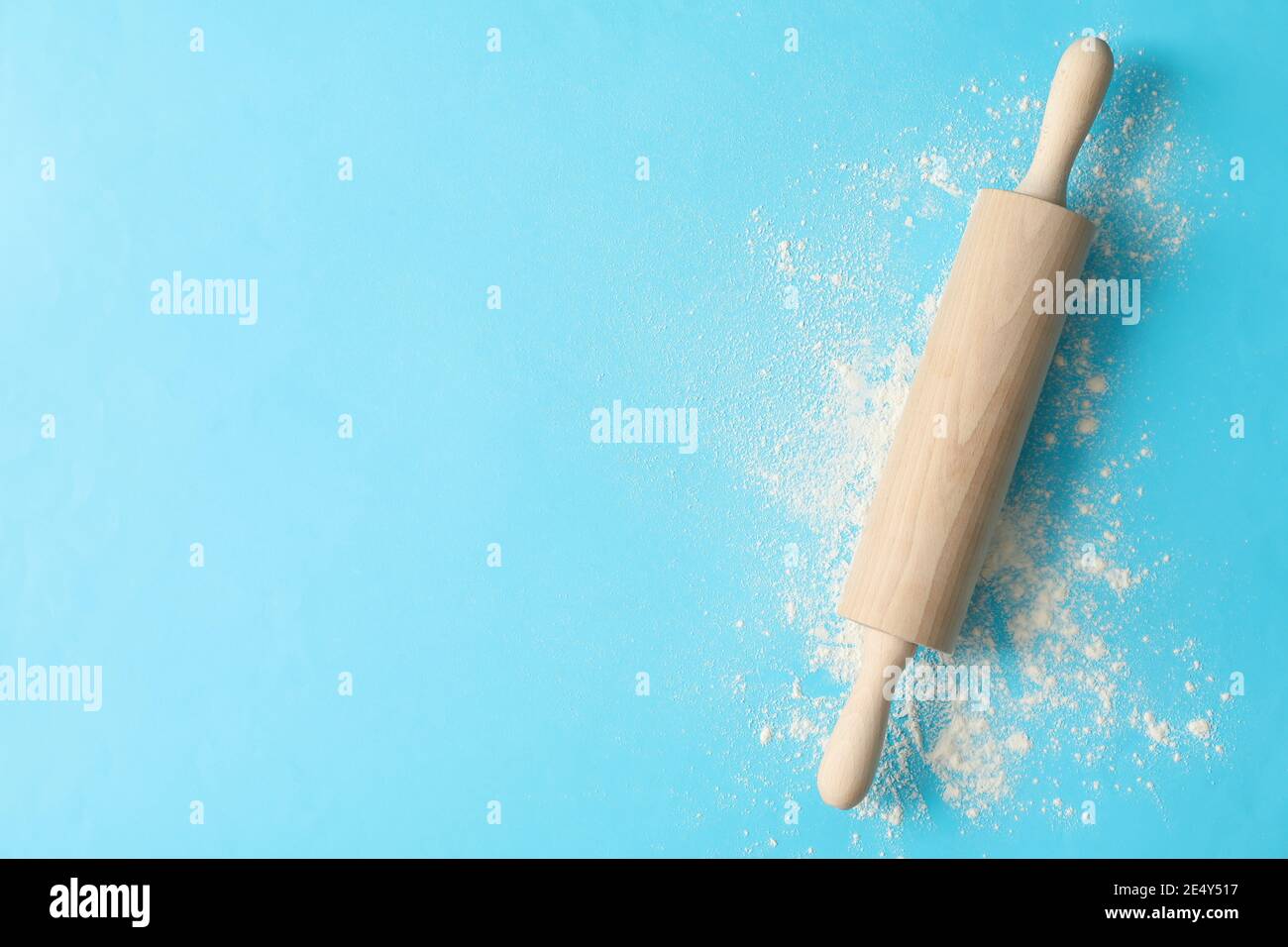 Rolling pin and flour on blue background Stock Photo - Alamy