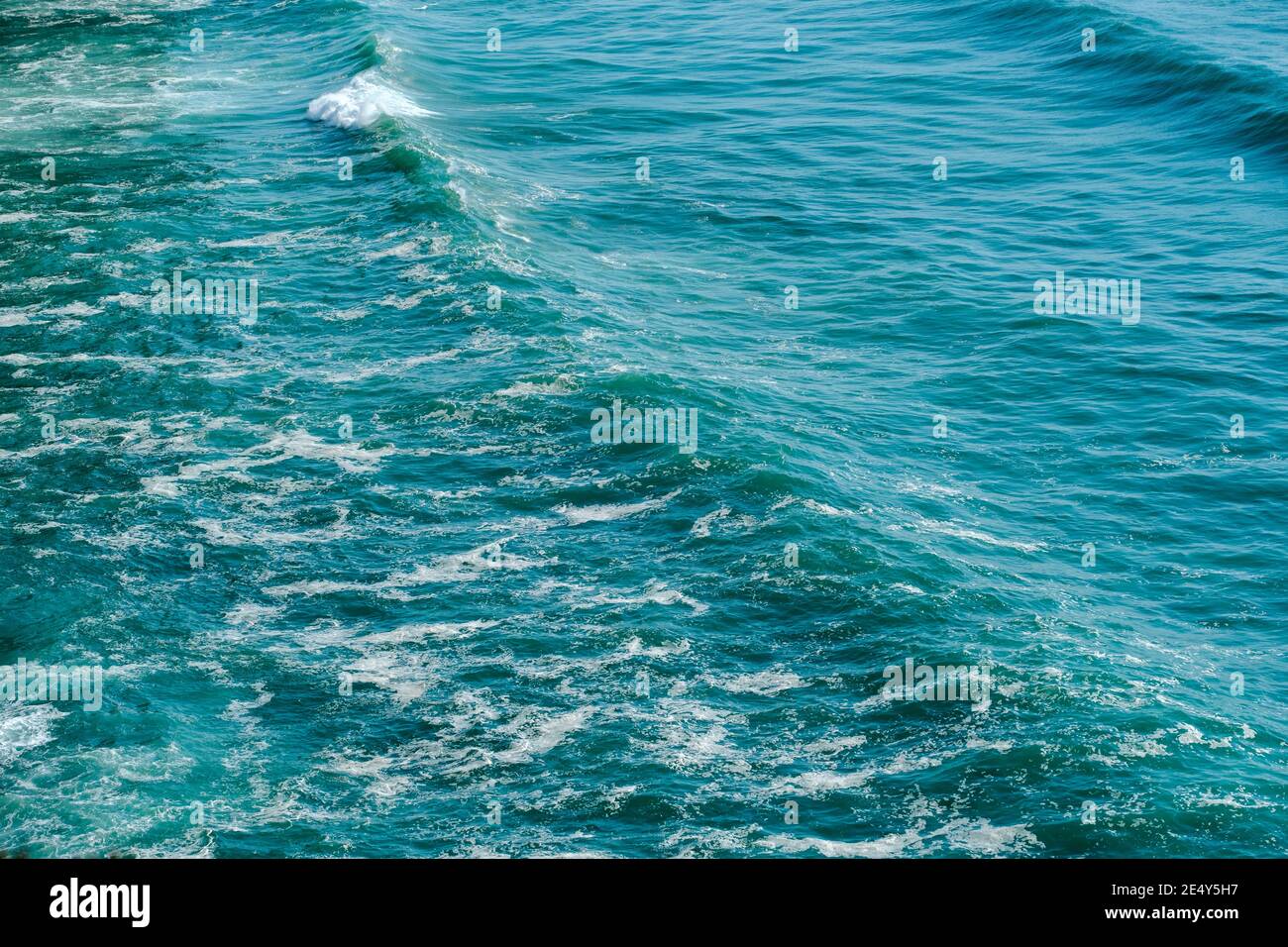 safire colored waves of the sea with its surf approaching the beach ...