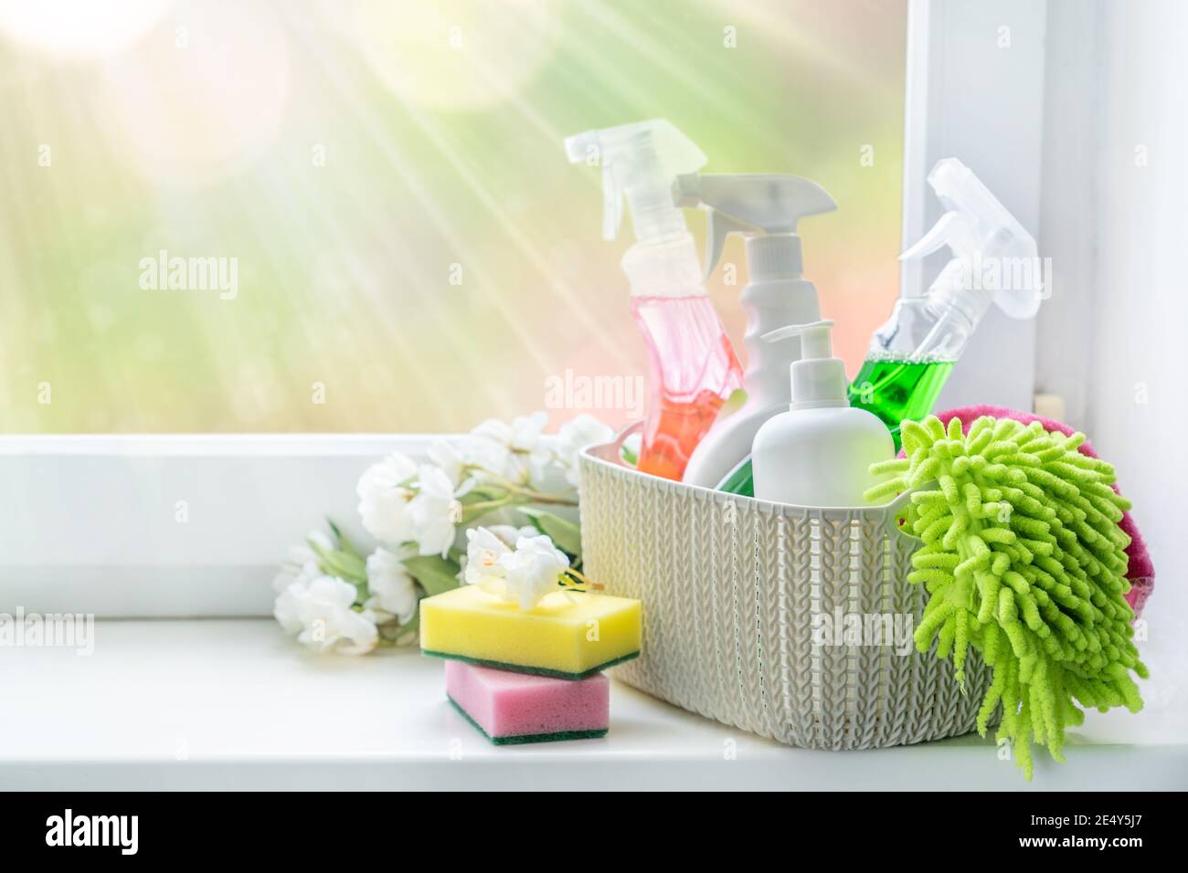 Spring cleaning concept - cleaning supplies and flowers on blur ...