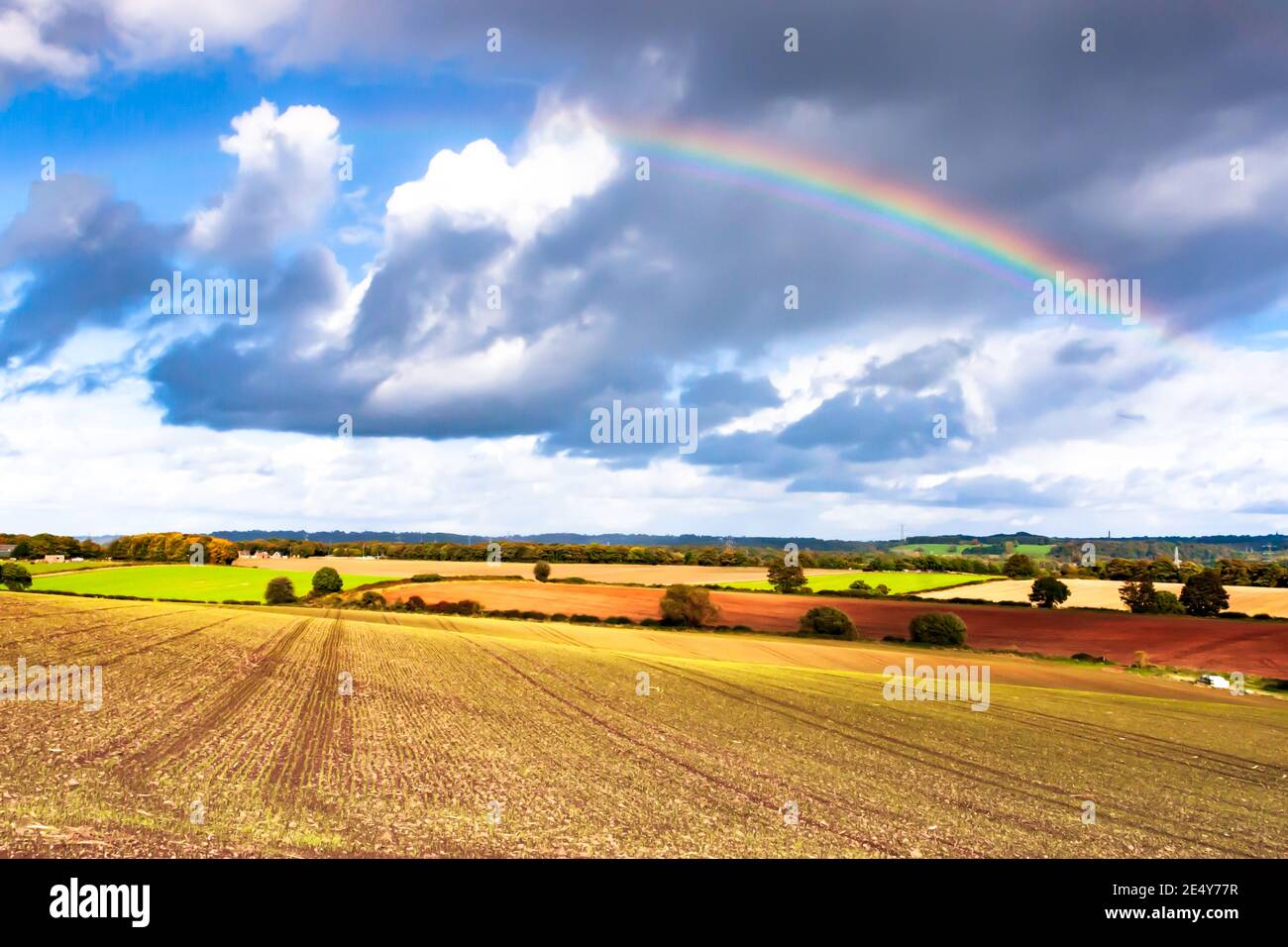 A rainbow in a blue sky over farm land Stock Photo - Alamy