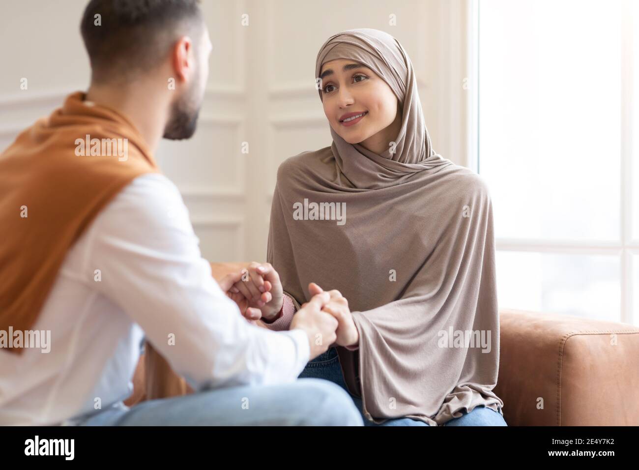 Modern Muslim Couple In Love Talking Holding Hands Sitting Indoors ...