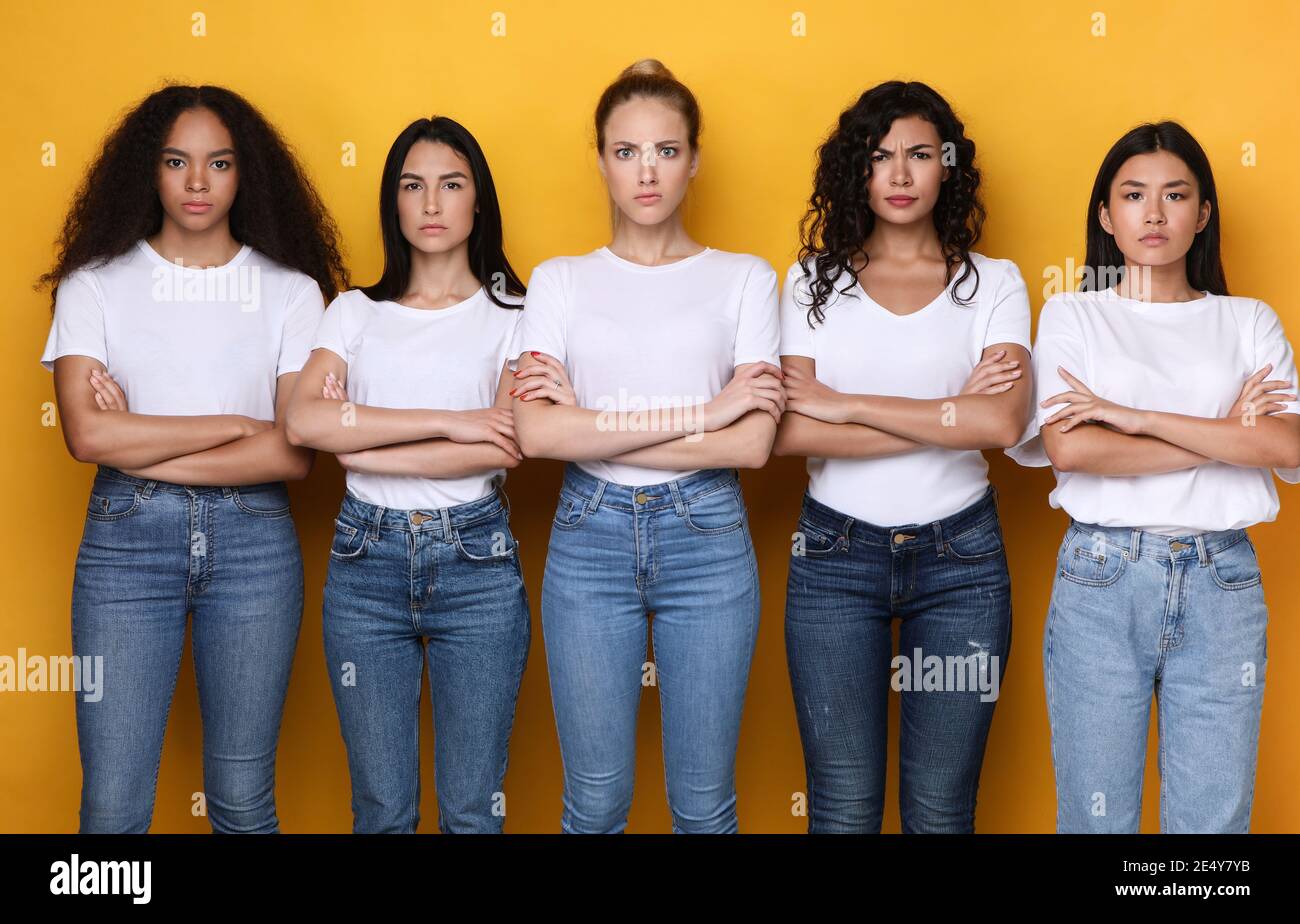 Five Discontented Mixed Women Posing Crossing Hands Over Yellow ...