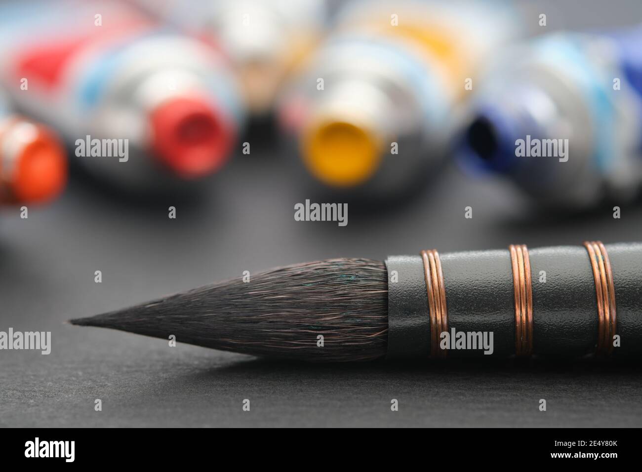 Artistic paintbrush for watercolor painting closeup on black paper ...