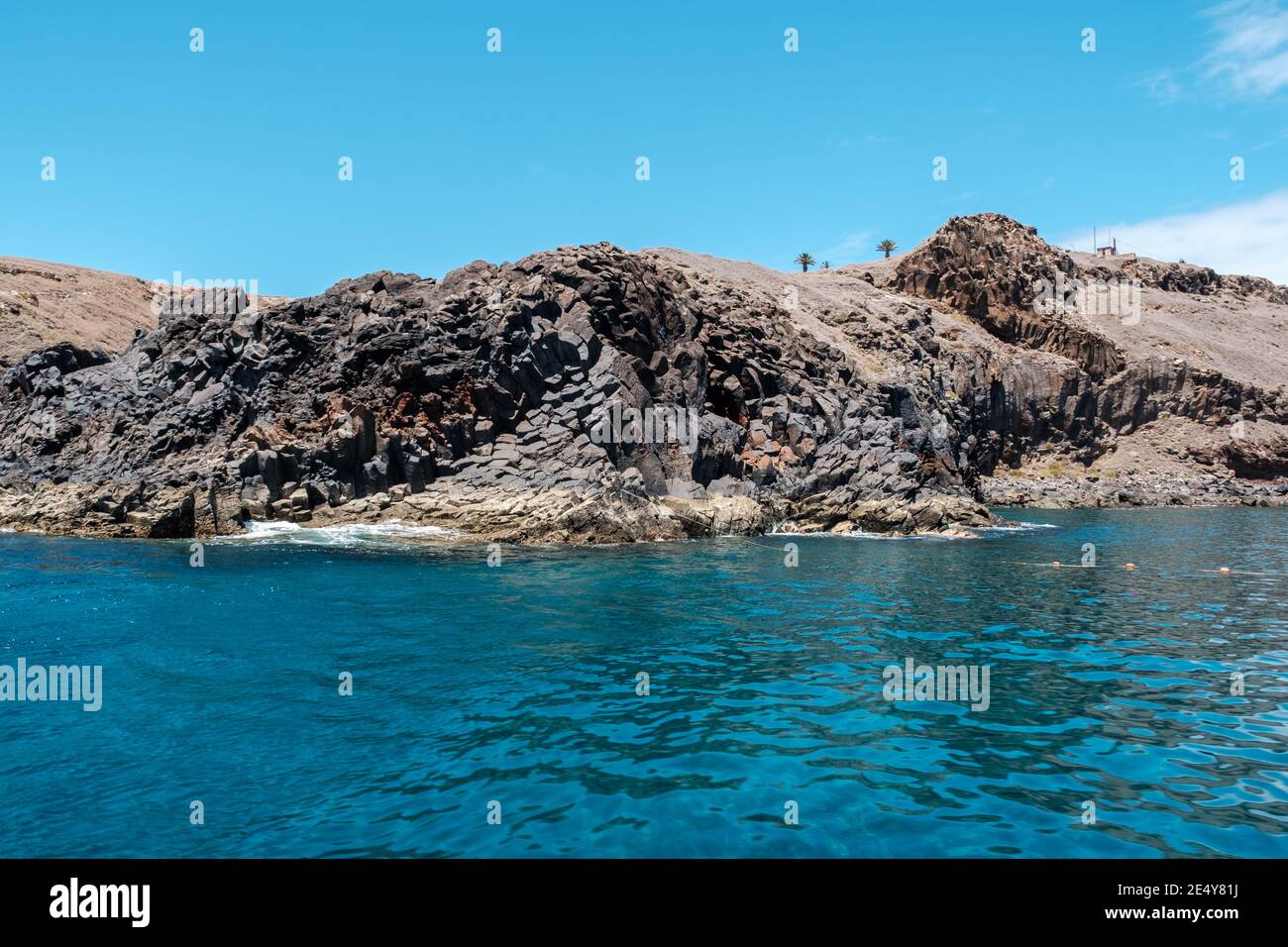 Tropical Island arid mountains full of dirt and rock in a summer day ...