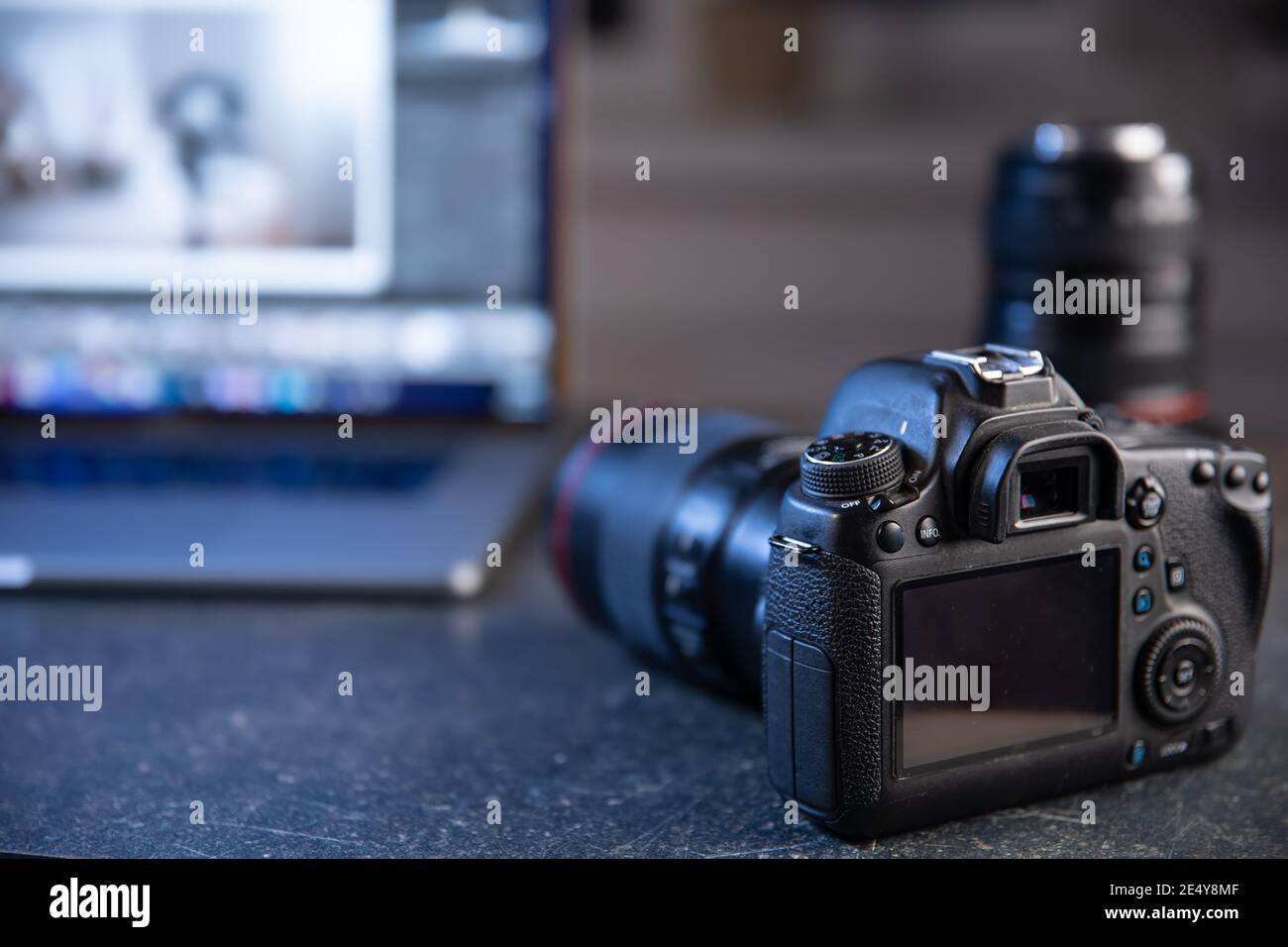 Professional camera on a blurred background with a laptop. The concept ...