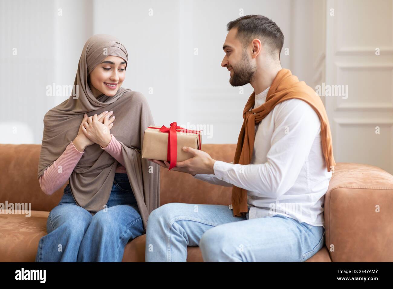 Muslim Husband Surprising Wife With A Gift Sitting At Home Stock Photo ...
