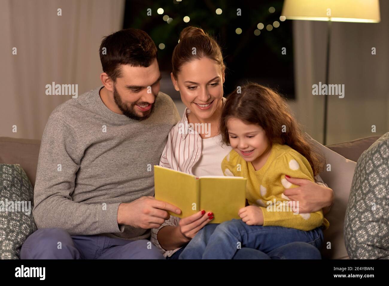 happy family reading book at home at night Stock Photo - Alamy
