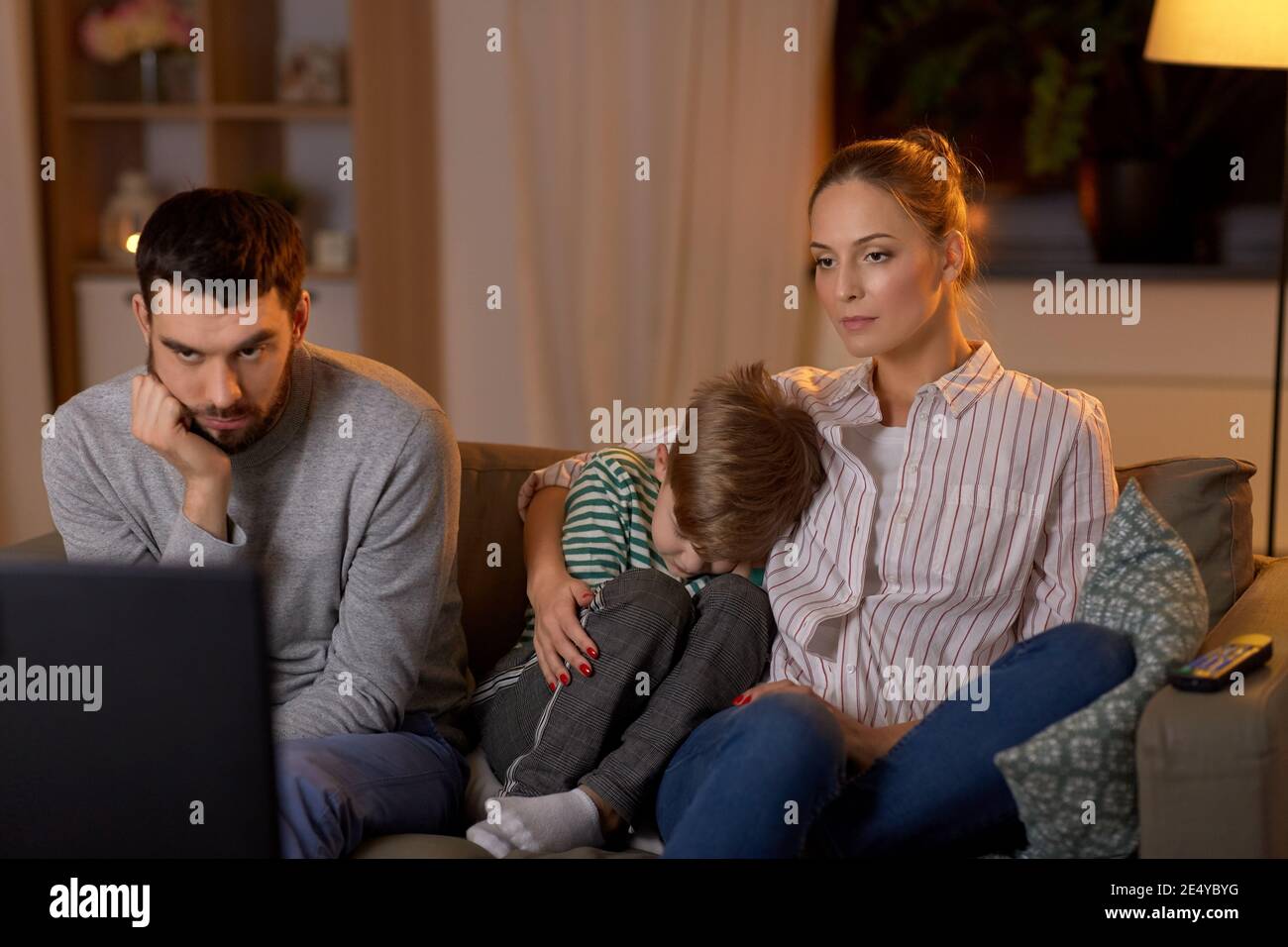 family watching something boring on tv at night Stock Photo - Alamy