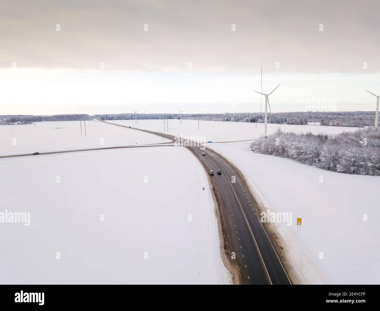Drone view of the paved road and wind turbines on a winter day. Wind ...