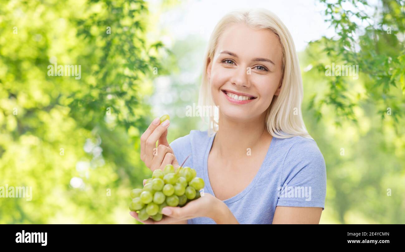 happy woman eating grapes Stock Photo - Alamy