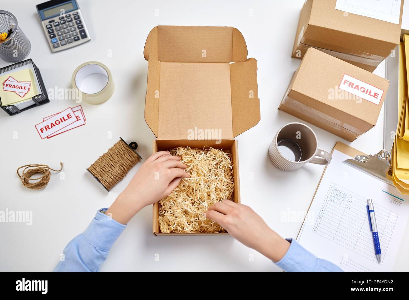 hands with straw filler in parcel at post office Stock Photo - Alamy