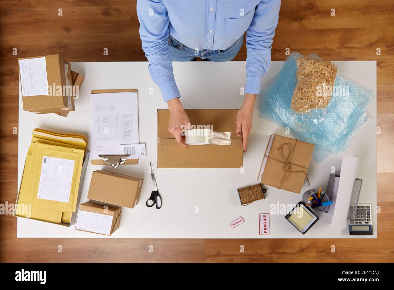woman packing parcel box with adhesive tape Stock Photo - Alamy