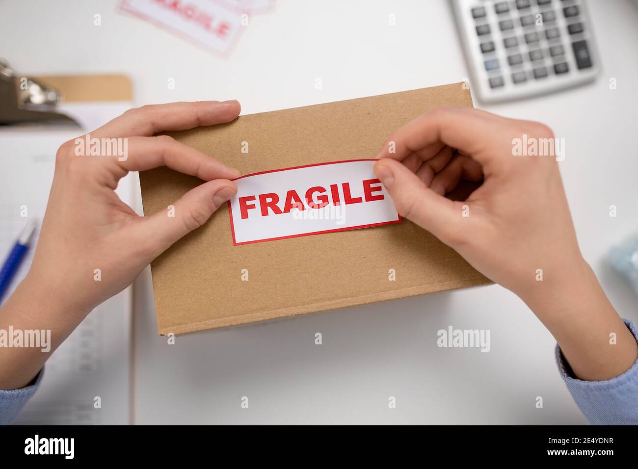 woman sticking fragile mark to parcel box Stock Photo - Alamy