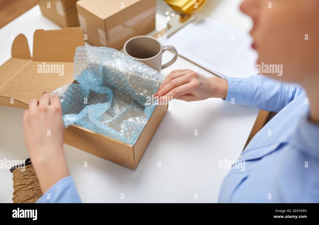 woman packing mug to parcel box at post office Stock Photo - Alamy