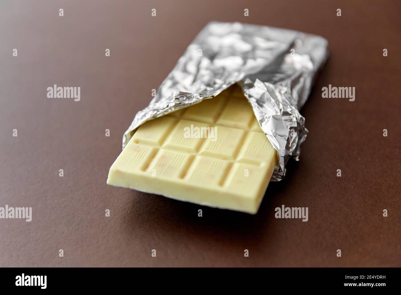 white chocolate bar in foil wrapper on brown Stock Photo - Alamy