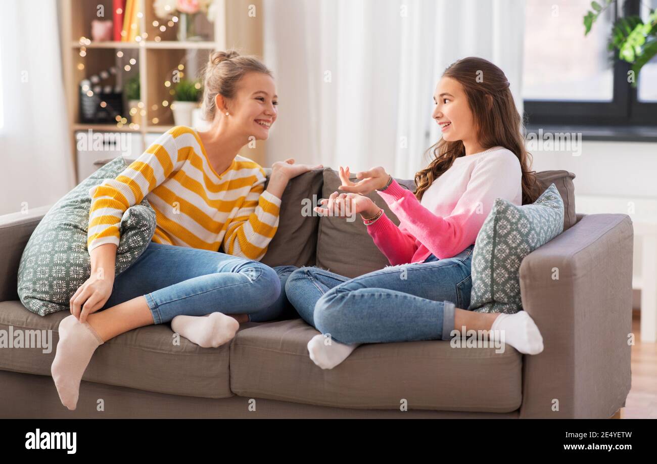 happy teenage girls talking on sofa at home Stock Photo - Alamy