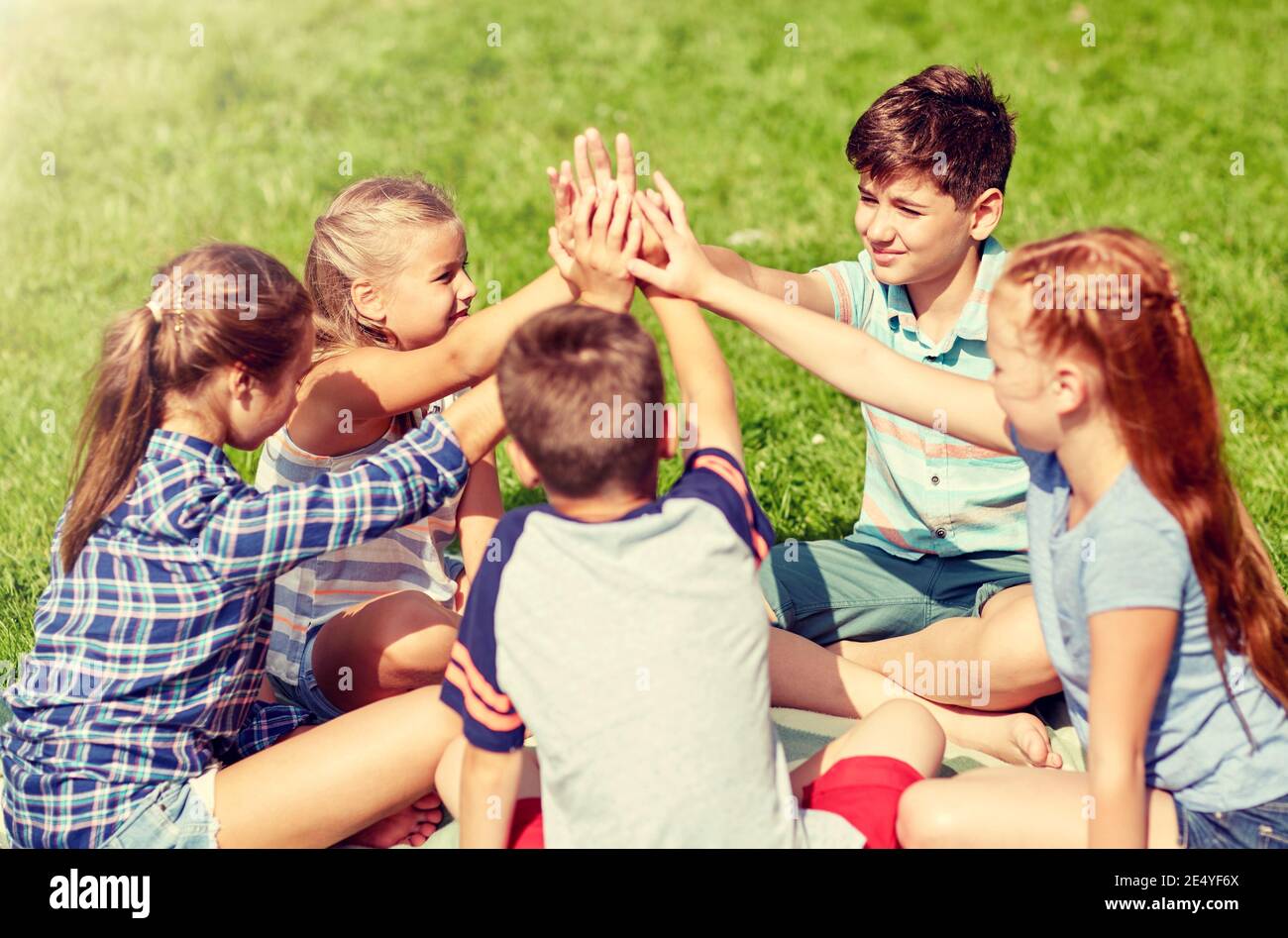 group of happy kids making high five outdoors Stock Photo - Alamy