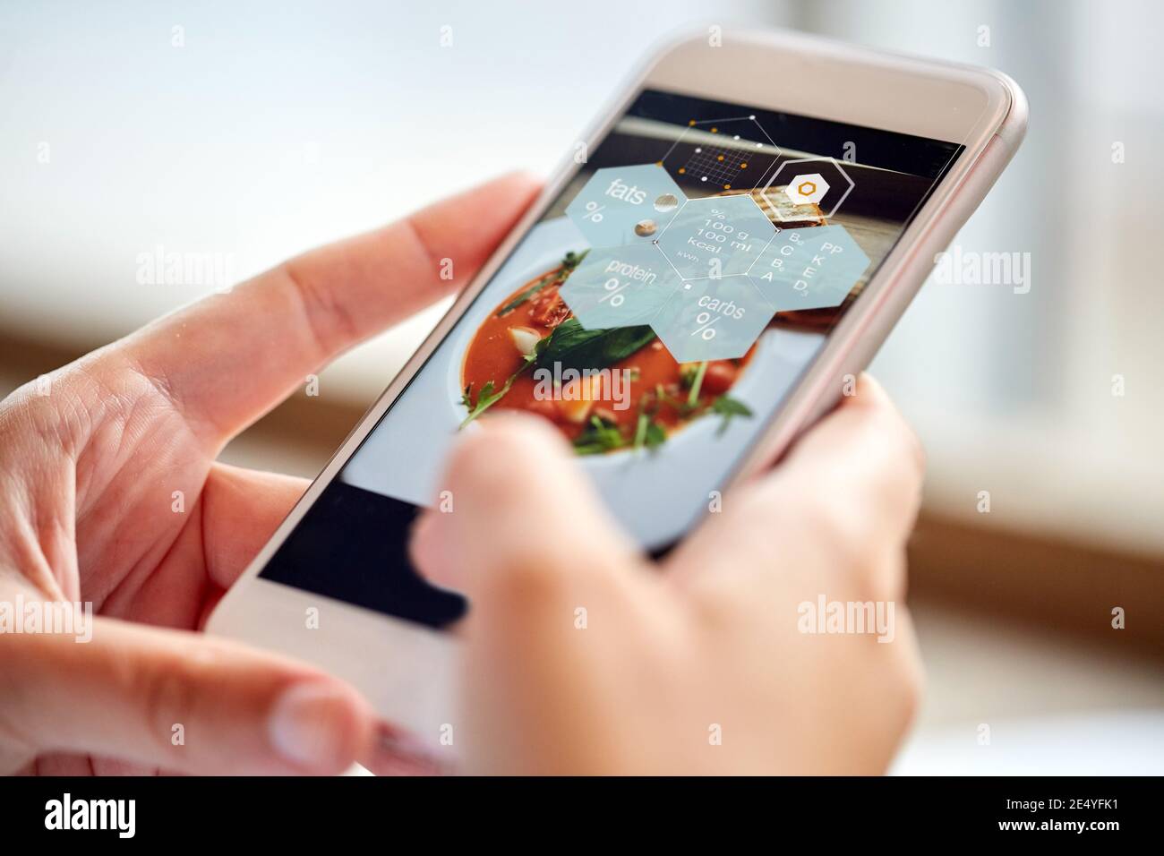 hands with phone and food nutritional value chart Stock Photo - Alamy