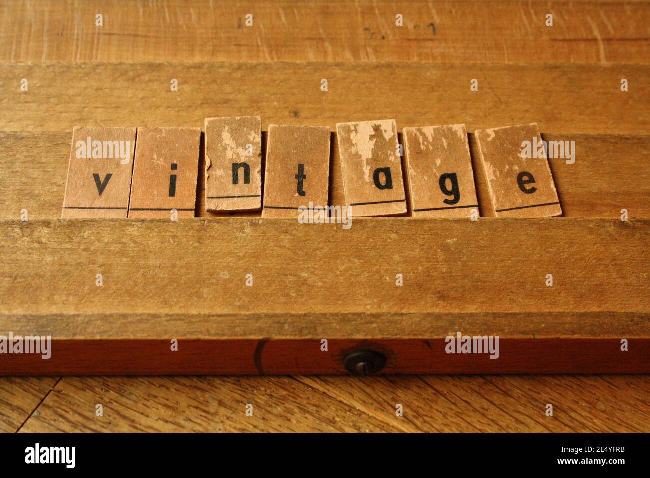 The word `vintage` made from cardboard lettercards on old wooden board ...
