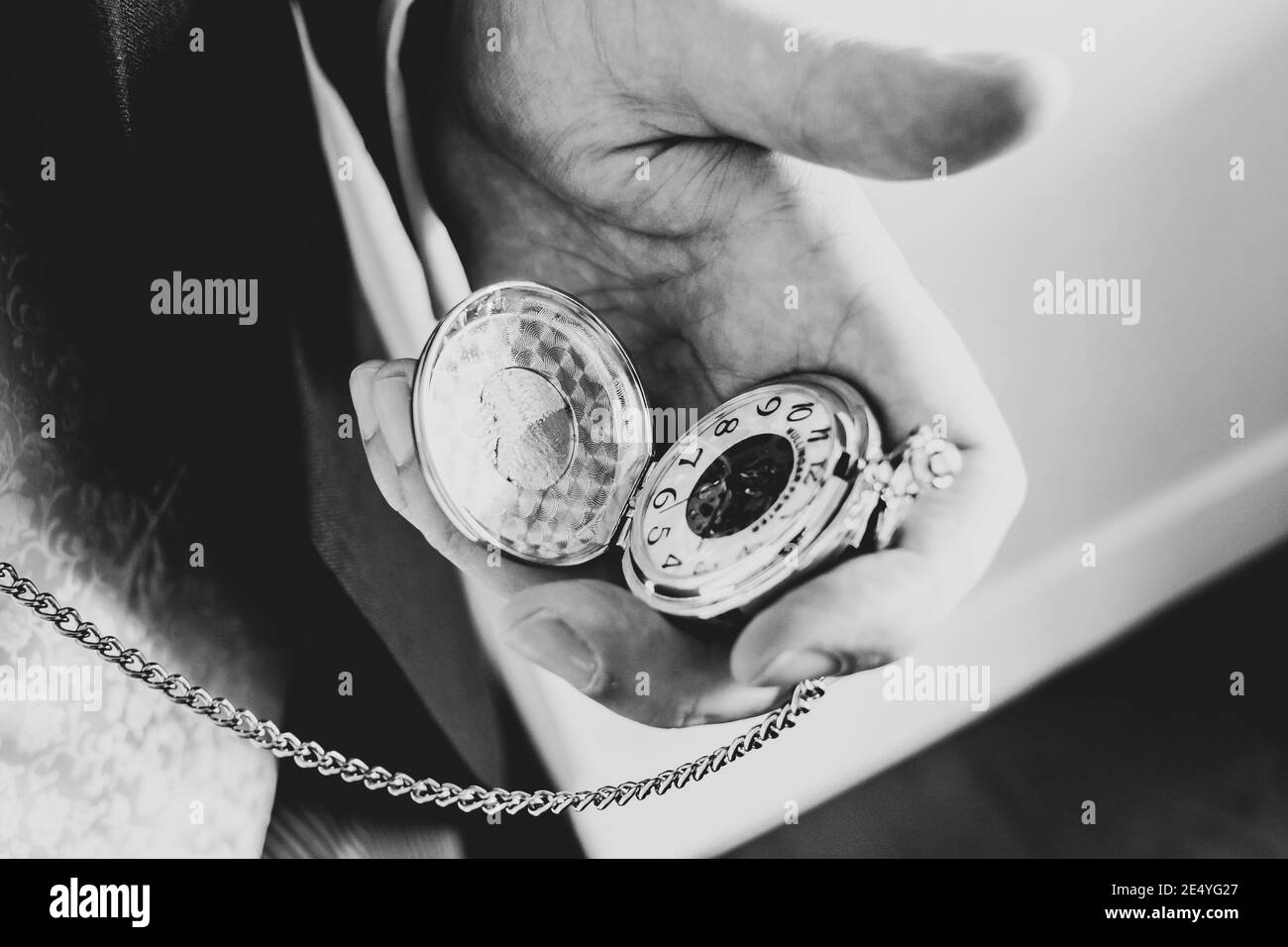 Checking the time in a suit on a silver gold pocket watch open and in ...