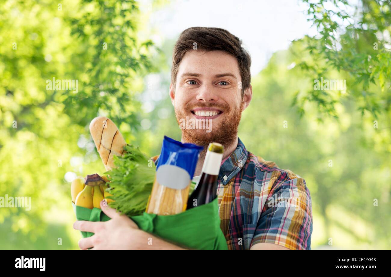 smiling young man with food in bag Stock Photo - Alamy