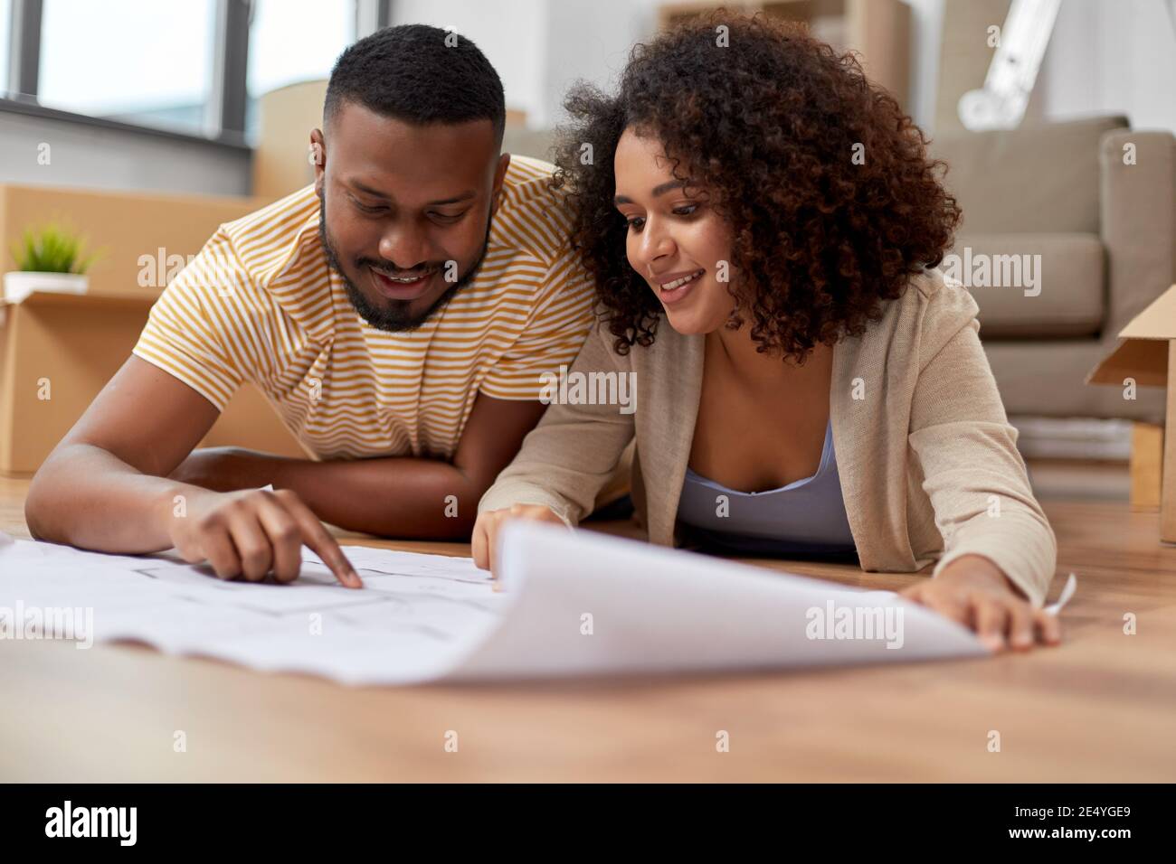 couple with boxes and blueprint moving to new home Stock Photo - Alamy