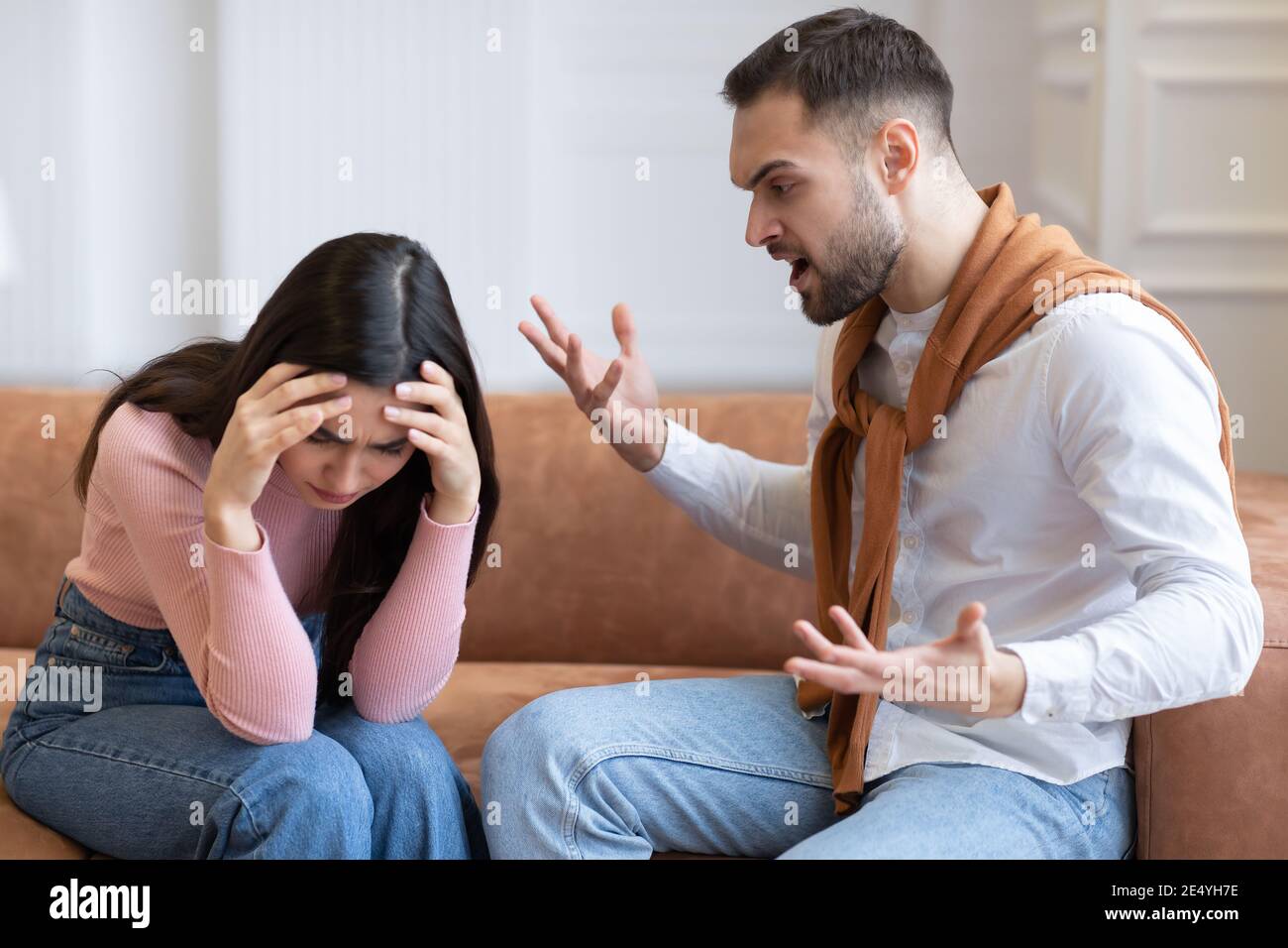 Aggressive Husband Shouting At Unhappy Wife Sitting On Sofa Indoor ...
