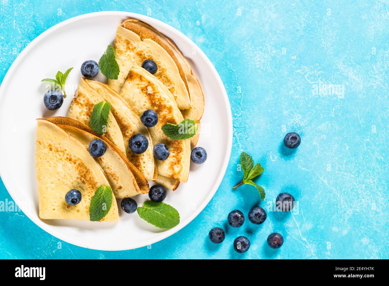 Crepes with blueberries at blue table Stock Photo - Alamy