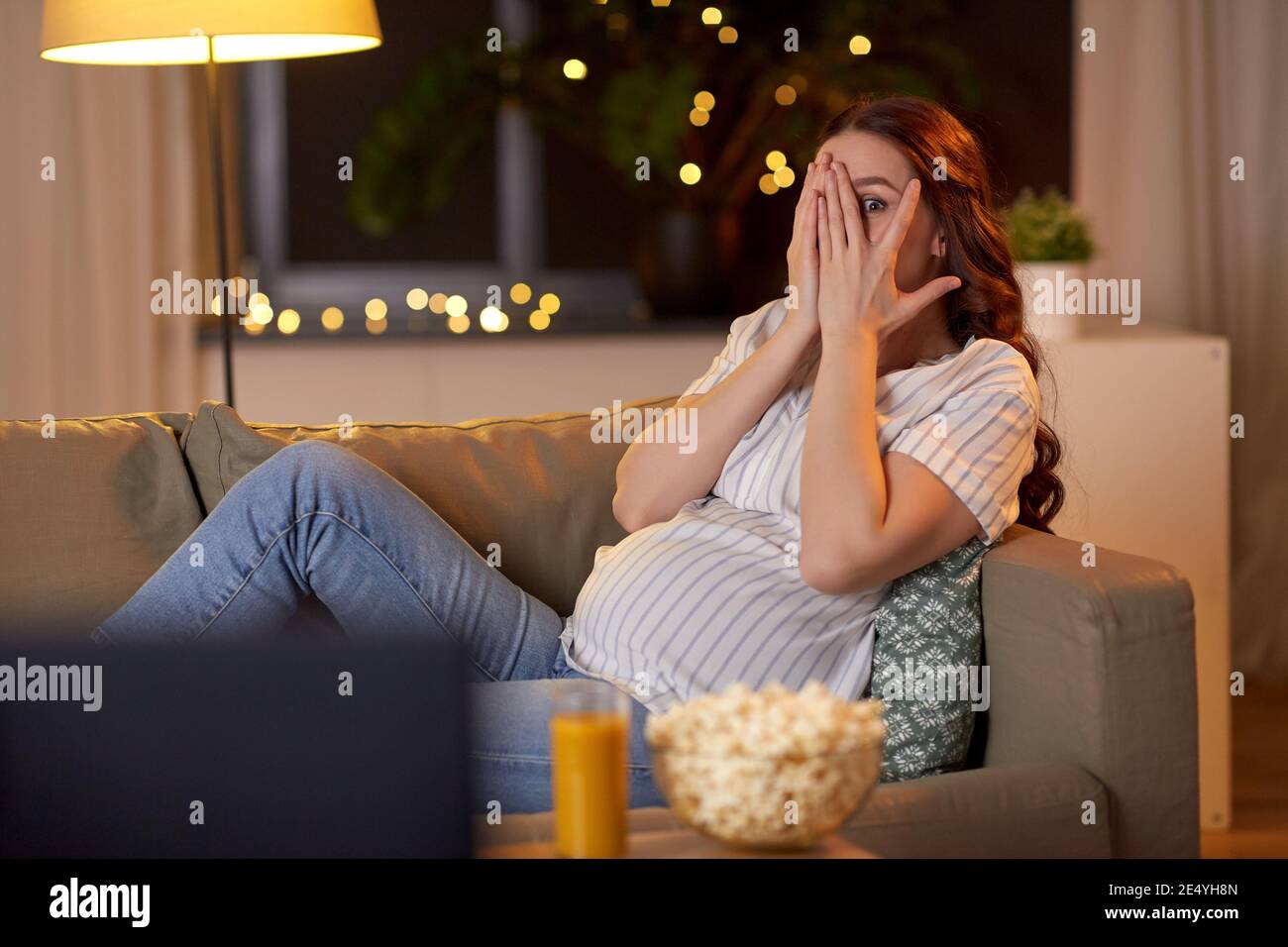 scared pregnant woman watching tv at home Stock Photo - Alamy