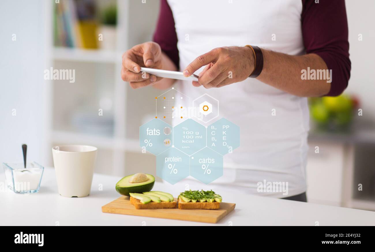 hands with phone and food nutritional value chart Stock Photo - Alamy