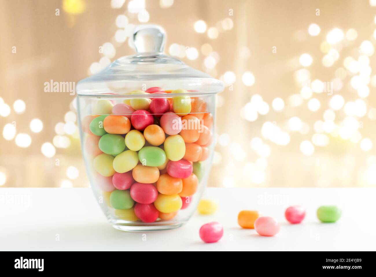 glass jar with candy drops over lights background Stock Photo - Alamy