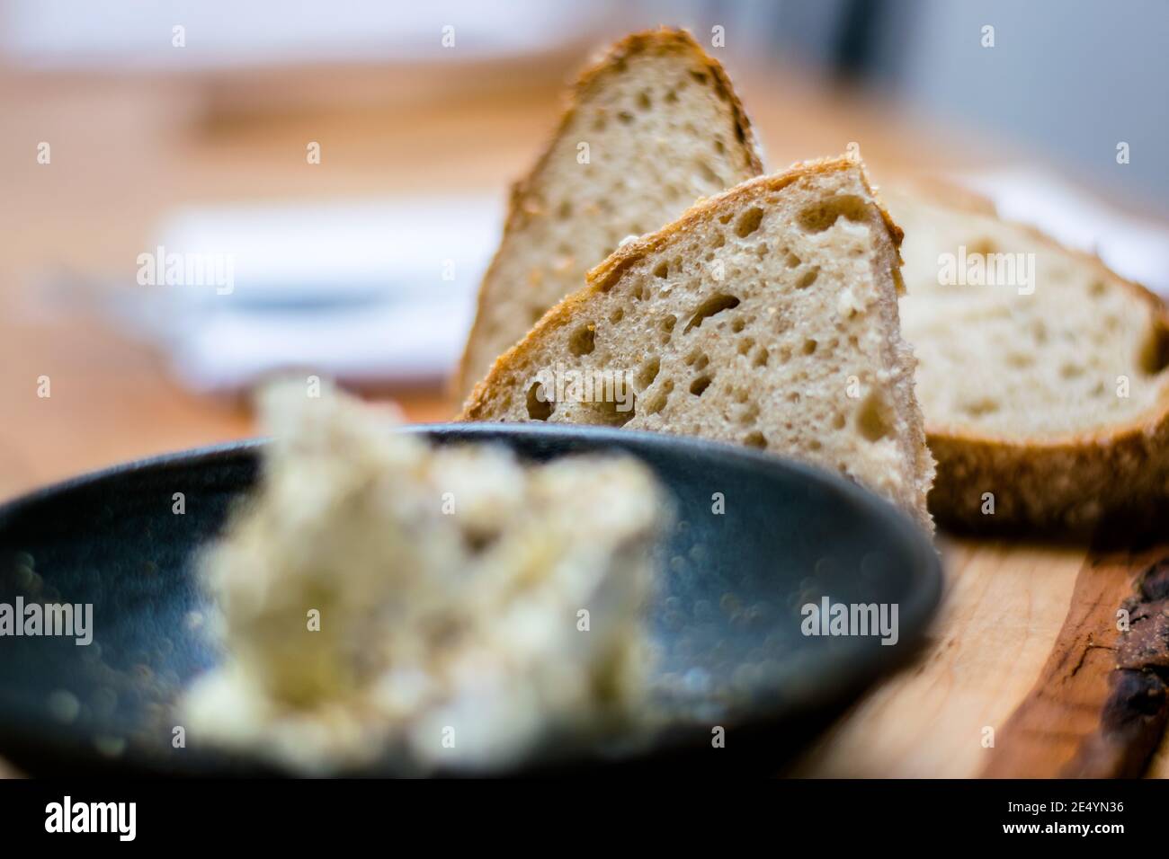 Bread and butter on a wooden plate at a restaurant Stock Photo - Alamy