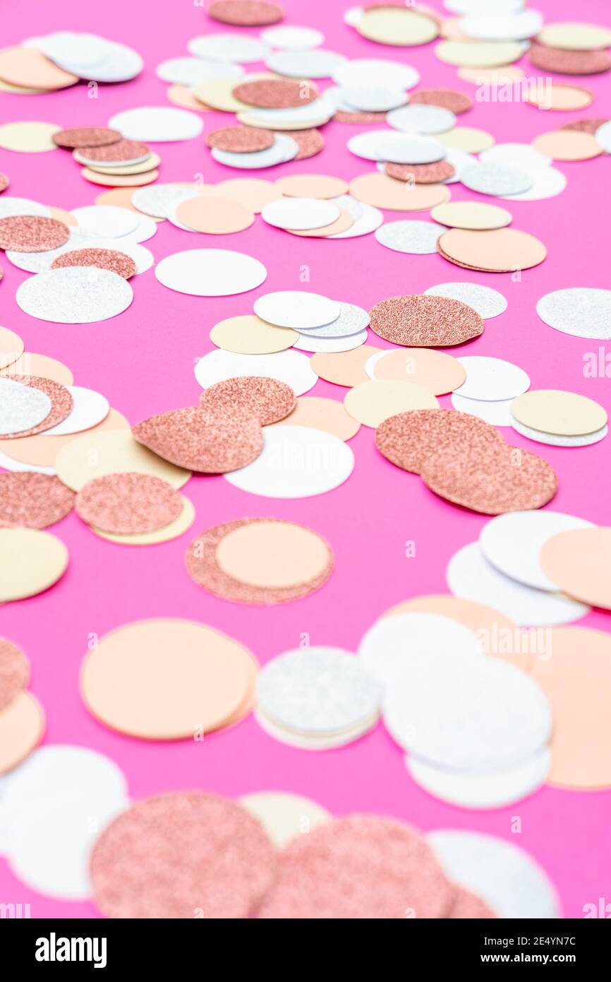 Multicolor pink, gold and white confetti on the bright pink background ...