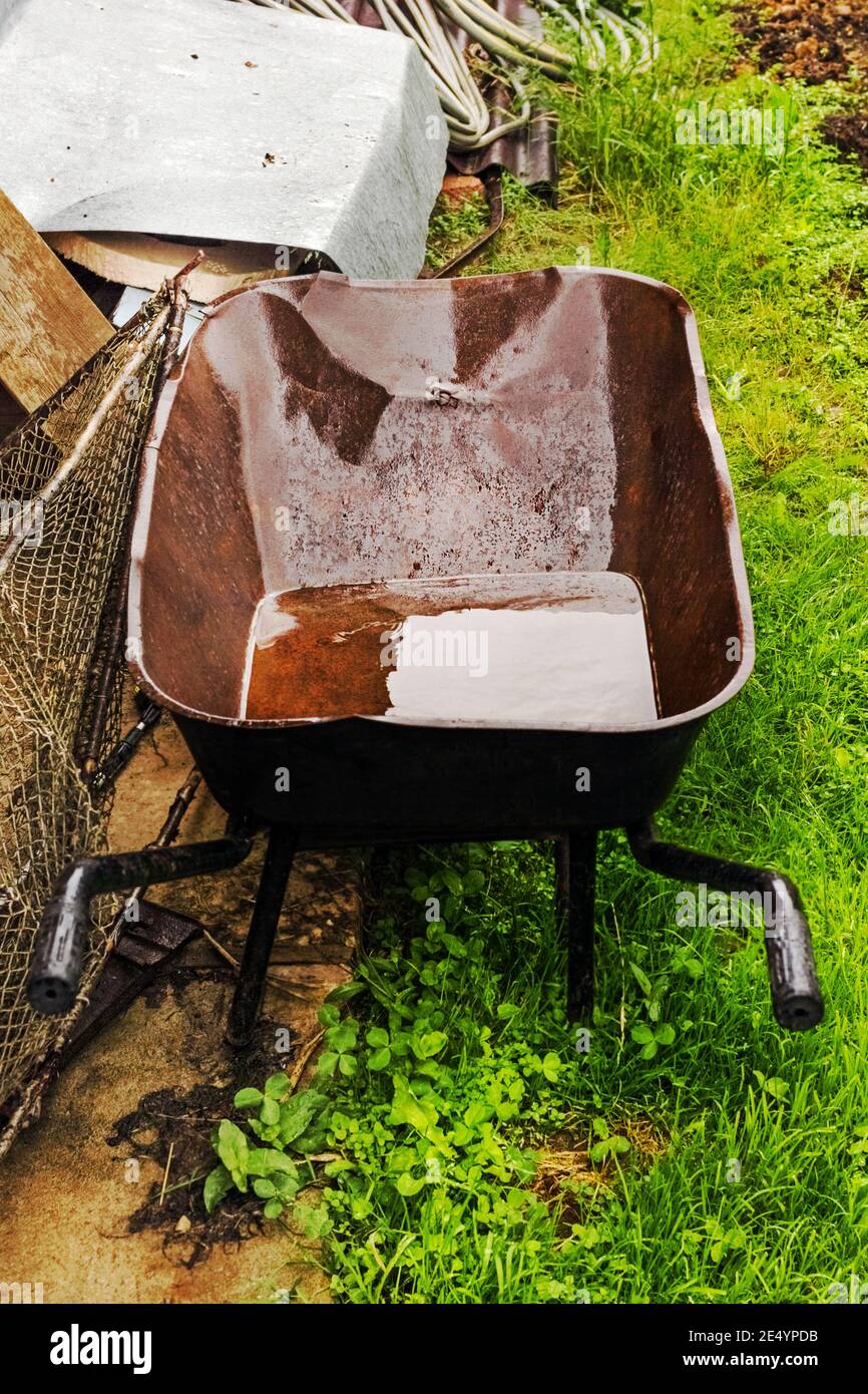 Big brown old metal garden wheelbarrow at summer day Stock Photo - Alamy